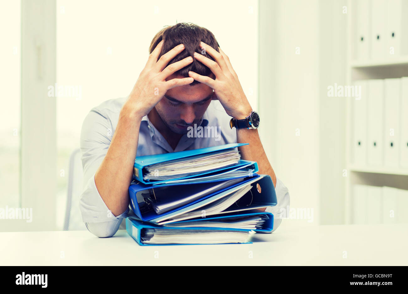 sad businessman with stack of folders at office Stock Photo - Alamy