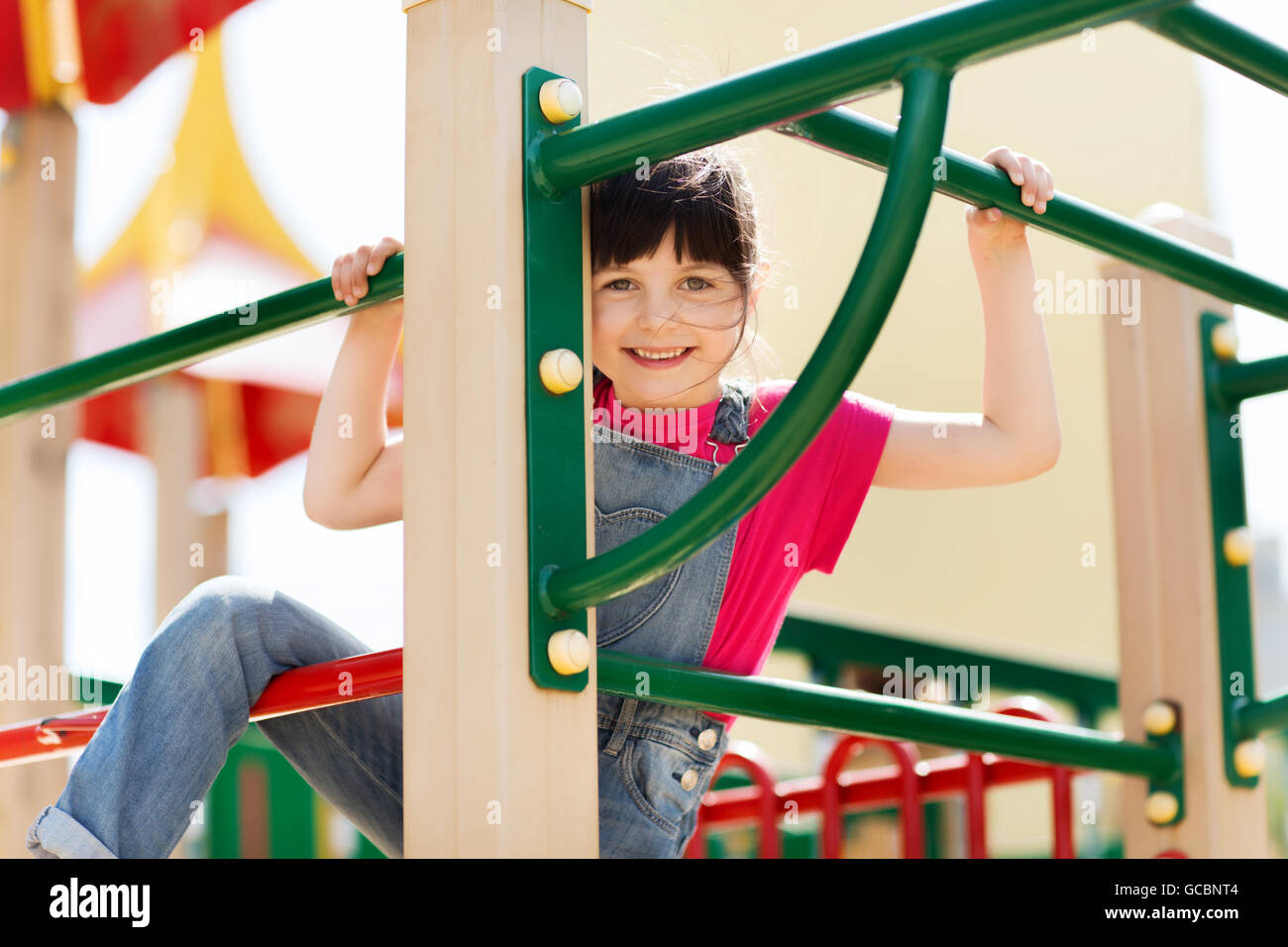 happy little girl climbing on children playground Stock Photo - Alamy