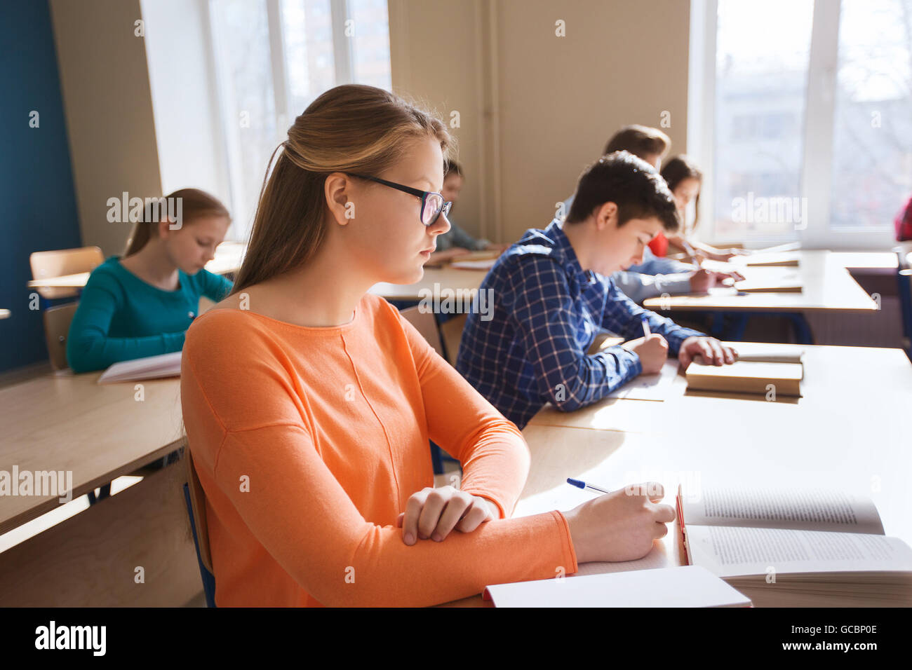 group of students with books writing school test Stock Photo - Alamy