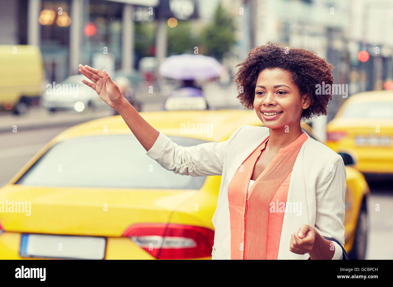 happy african woman catching taxi Stock Photo - Alamy