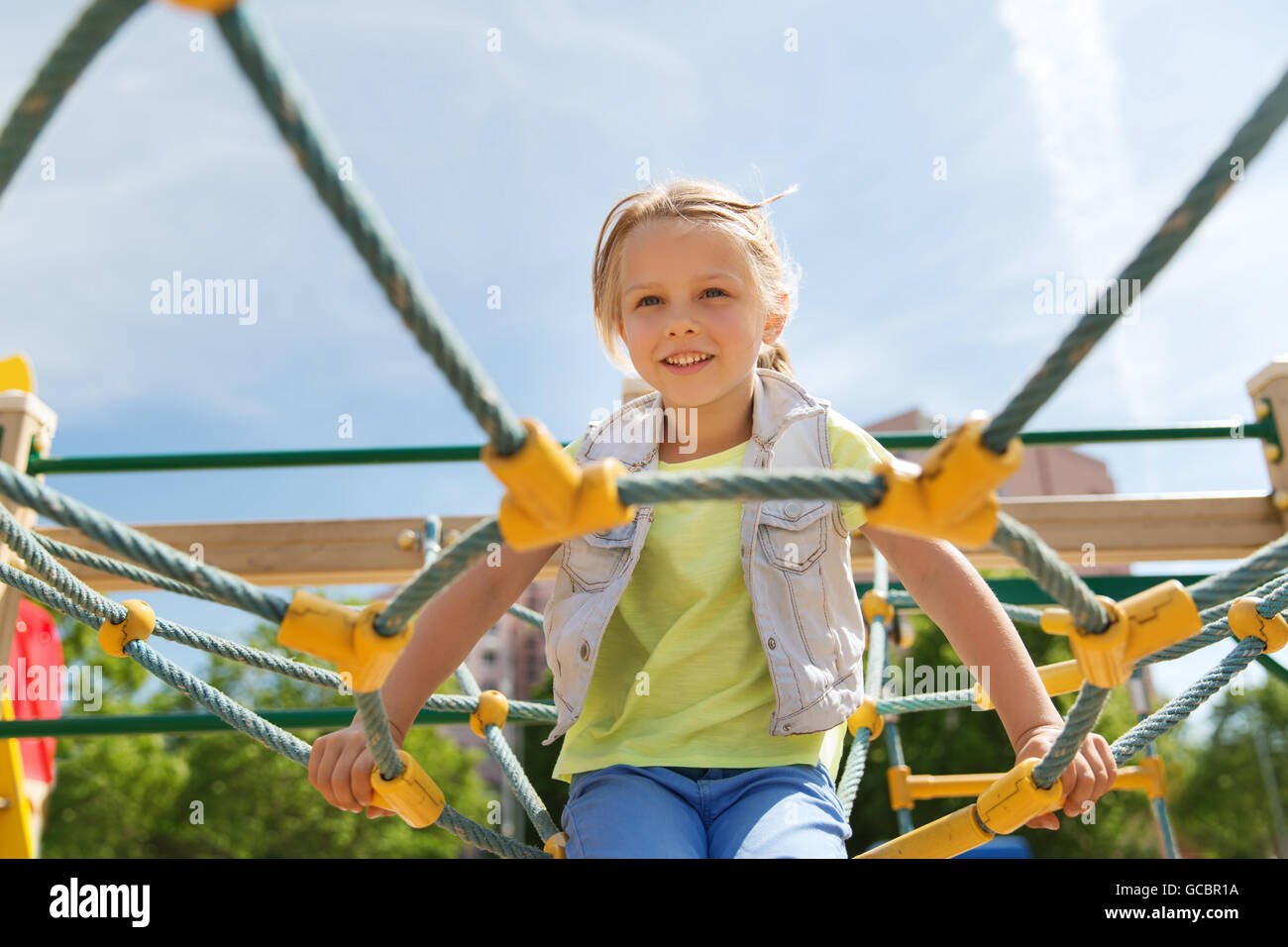 happy little girl climbing on children playground Stock Photo - Alamy