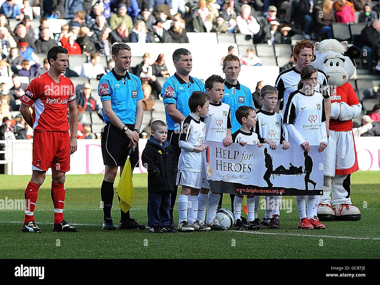 Milton Keynes Dons' captain Dean Lewington (2nd right) and mascot Mooie ...