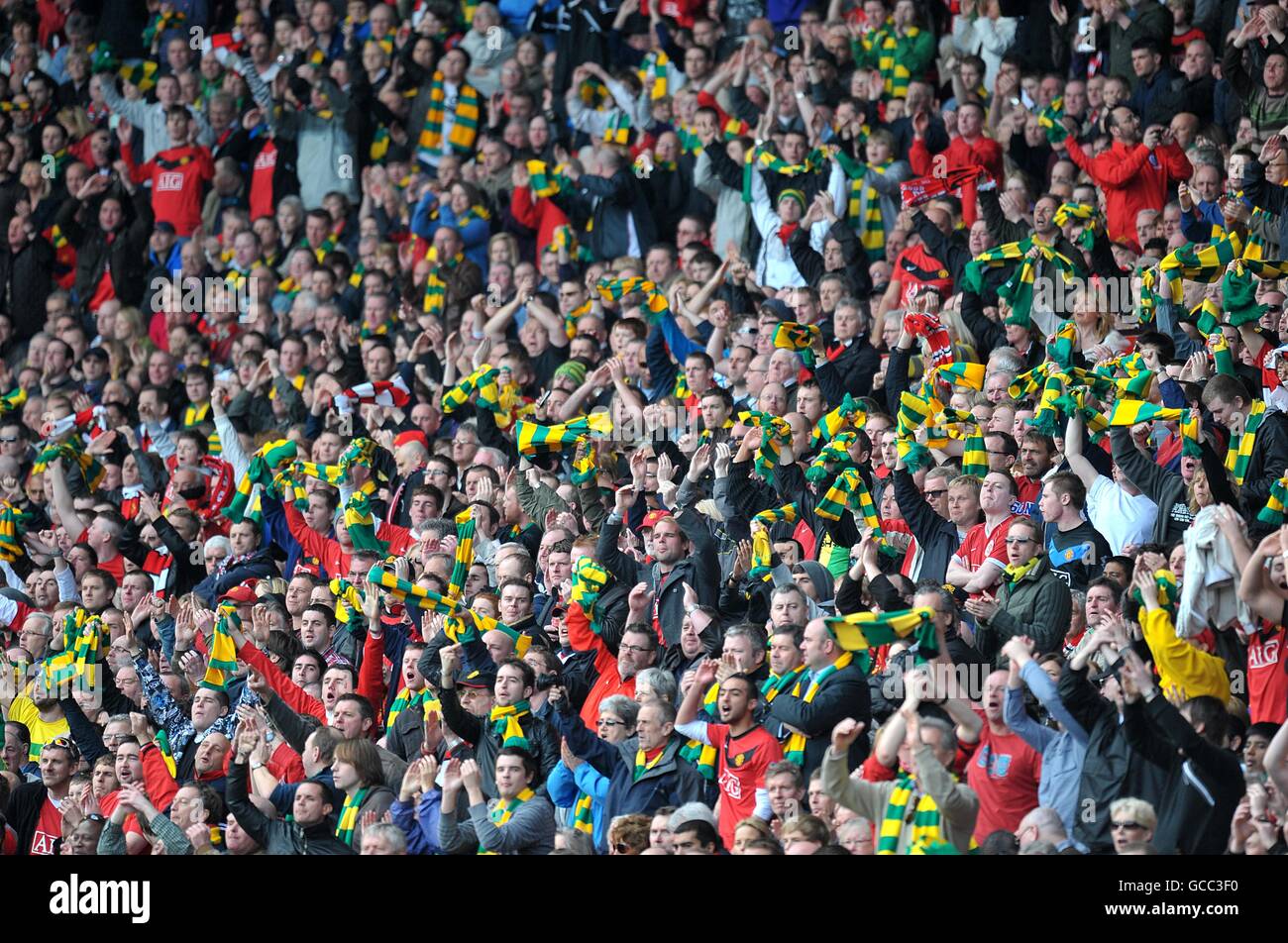 Manchester United fans wave their green and yellow scarfs in the stands ...