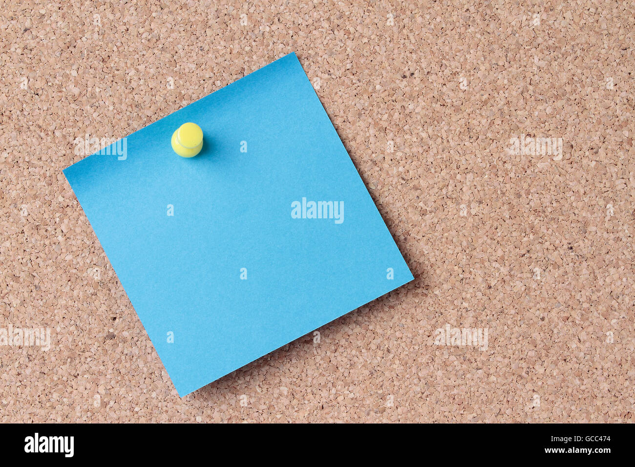 blue note on a cork board with a yellow push pin Stock Photo - Alamy