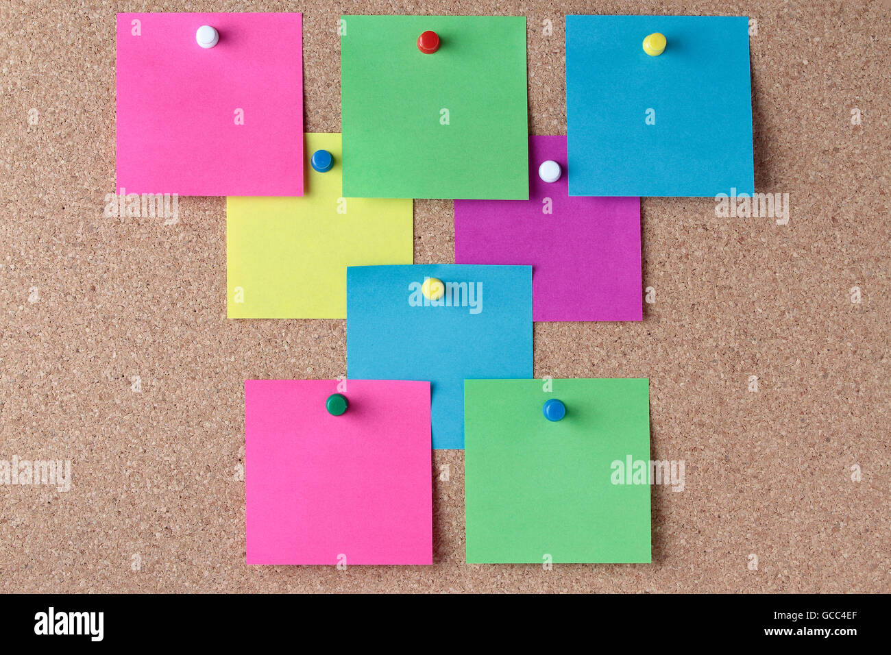 background of colored notes with colored push pins on a cork pinboard ...