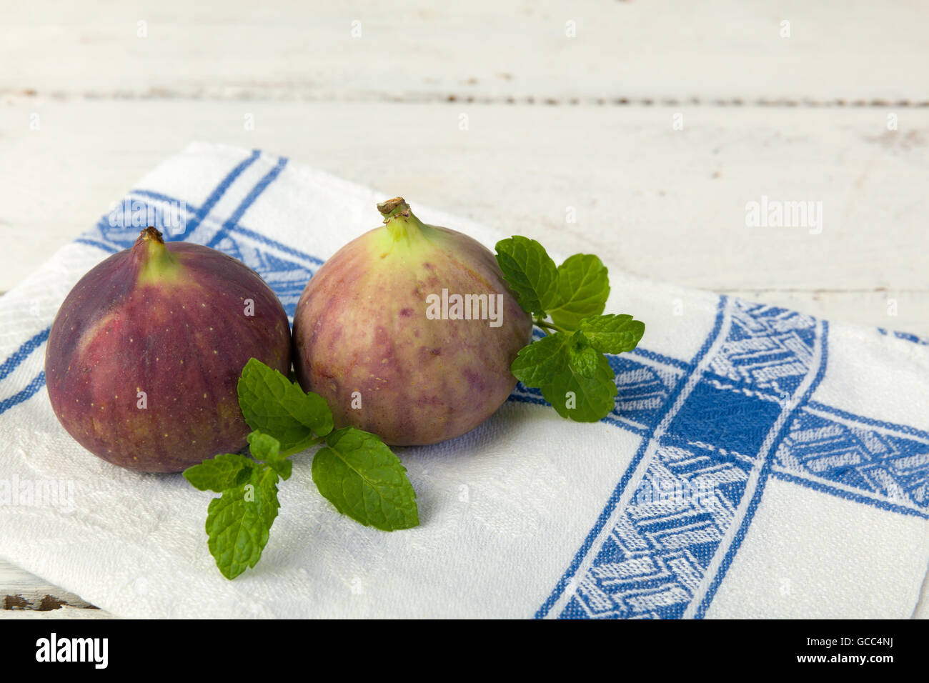 Two fresh figs on a textured vintage wooden table Stock Photo - Alamy
