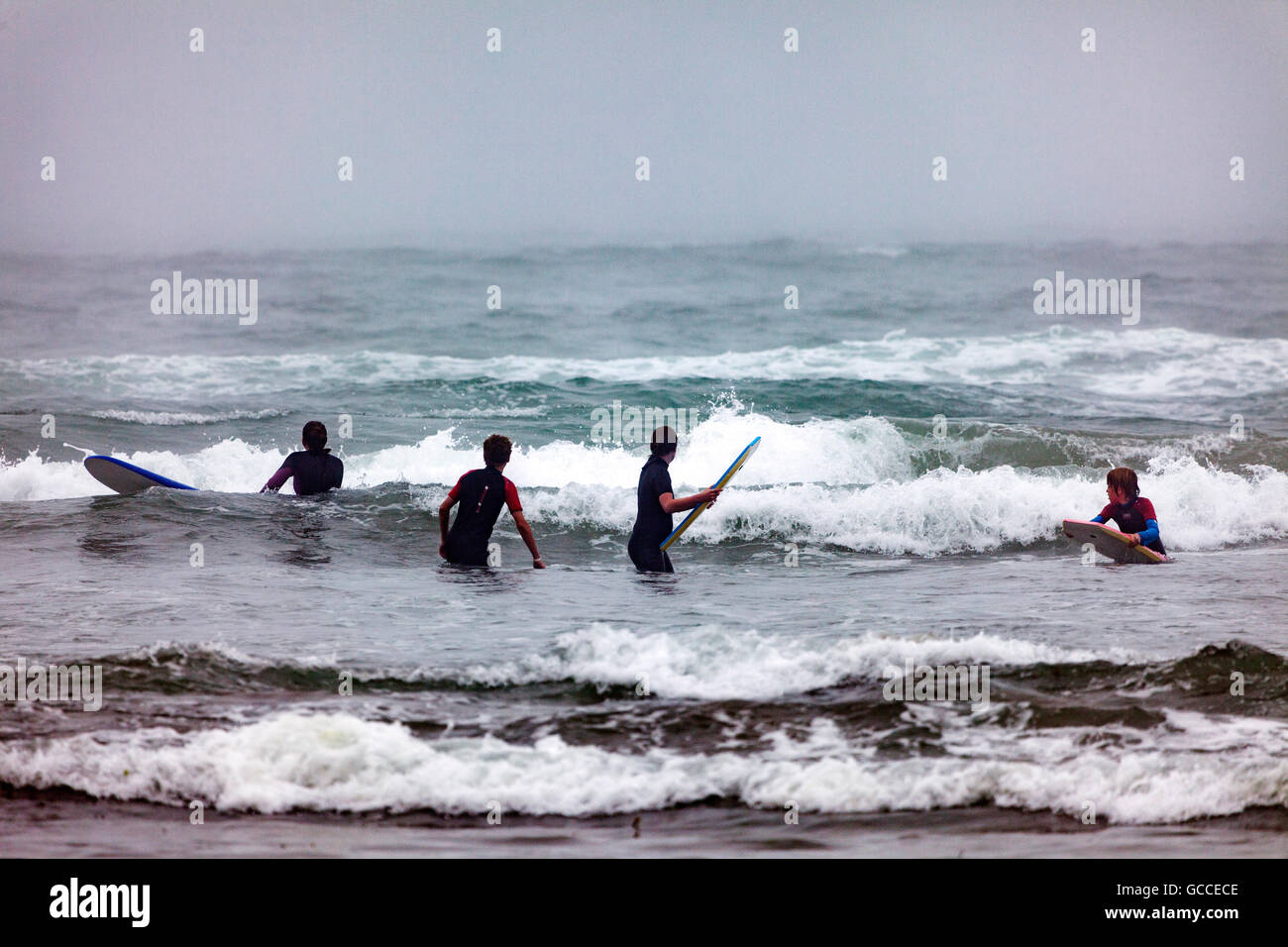 A group of surfers waiting in the sea to catch and wave for surfing at ...