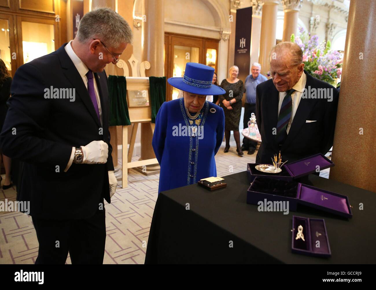 Queen Elizabeth II and the Duke of Edinburgh are presented gifts by ...