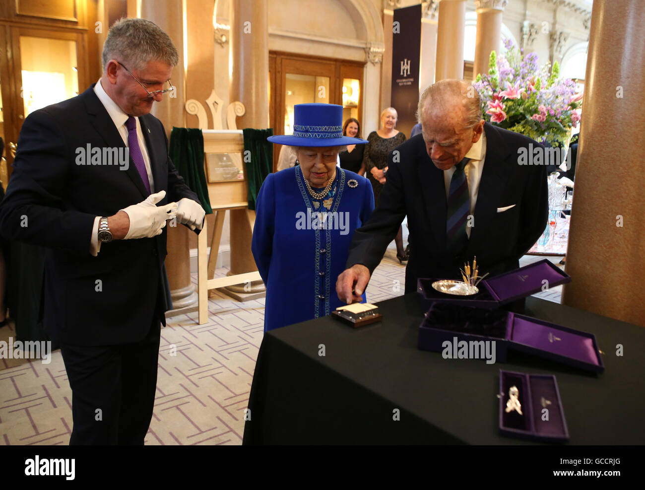 Queen Elizabeth II and the Duke of Edinburgh are presented gifts by ...