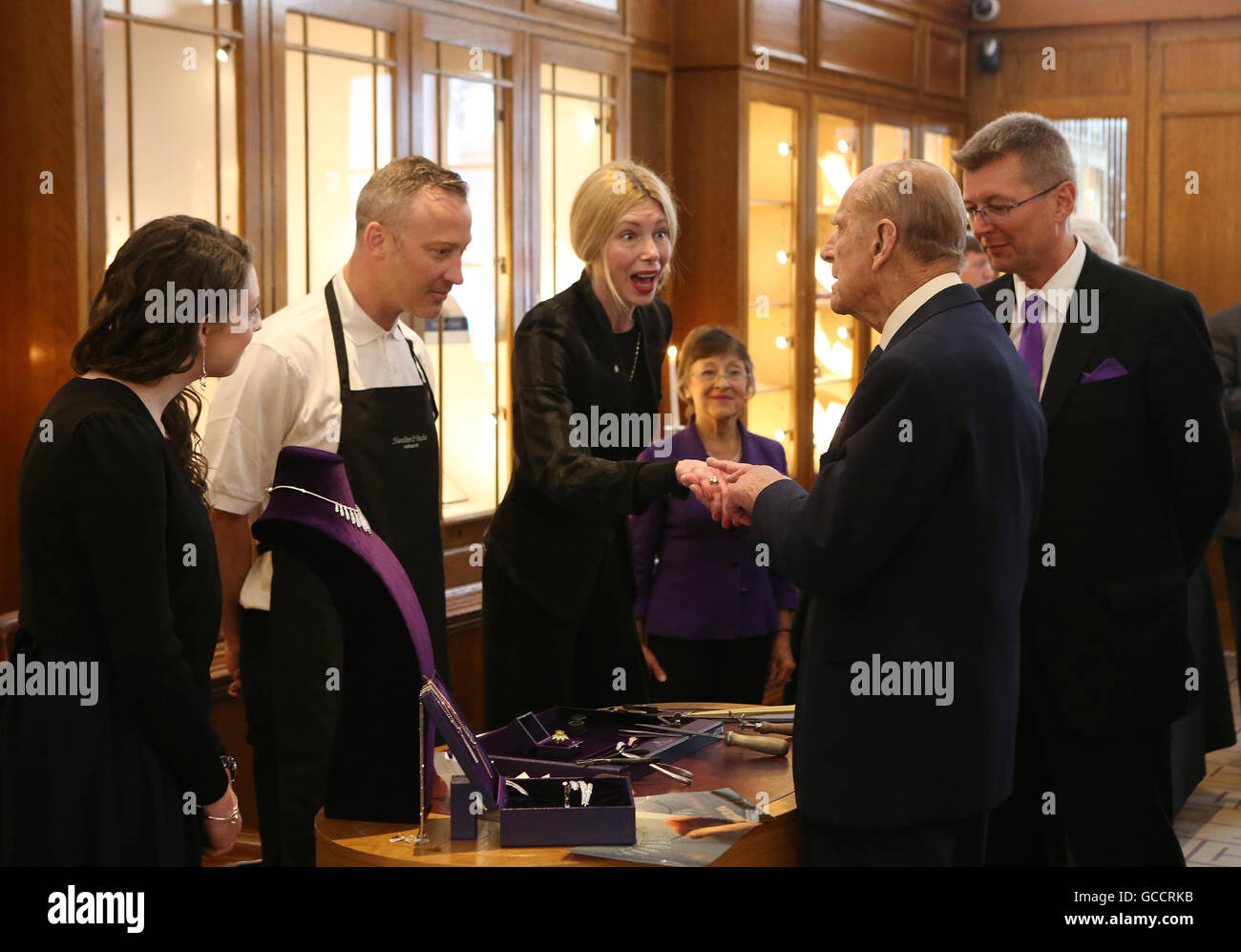 The Duke of Edinburgh looks at a ring on the hand of Debbie McKernan ...