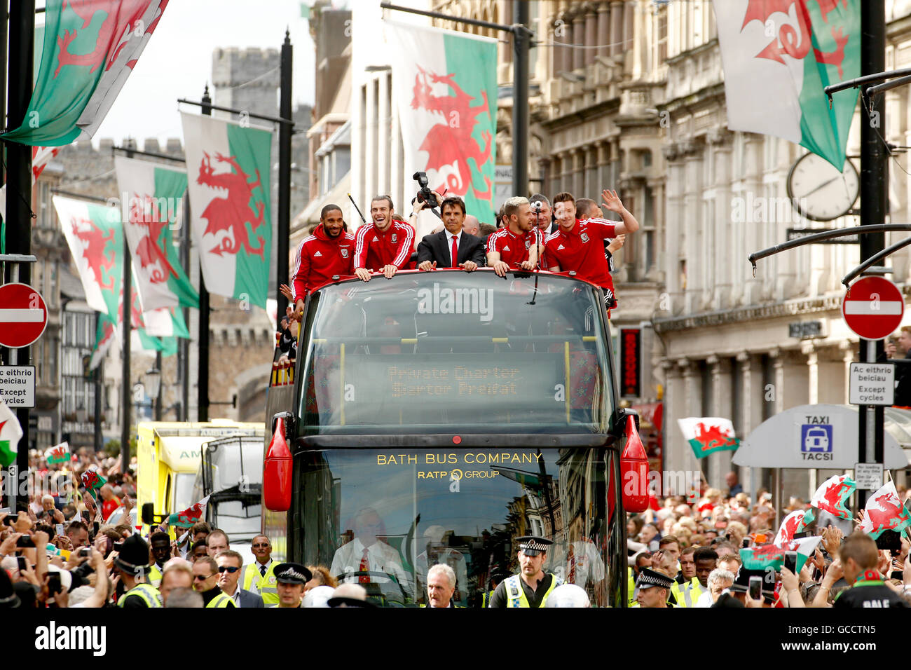 Wales players and manager Chris Coleman wave to fans on a open top bus ...