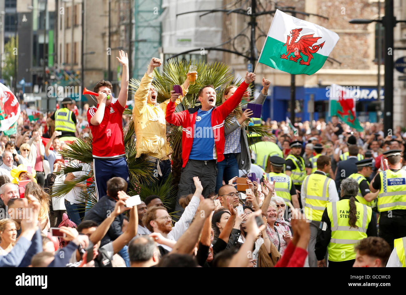 Spectators cheer on the Wales team during the open top bus homecoming ...