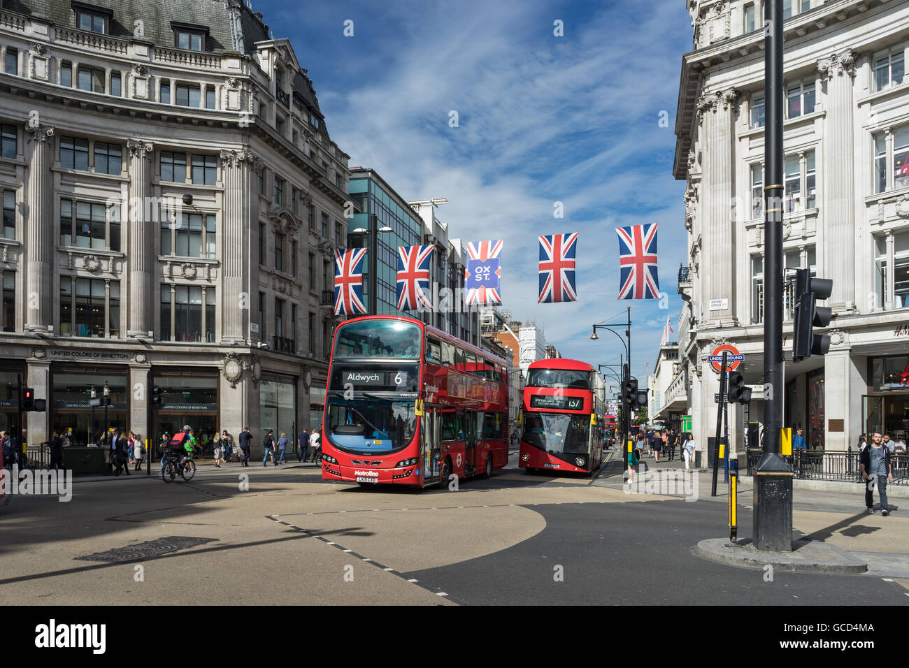 London Red Buses traveling along Oxford Street outdoors on a bright ...