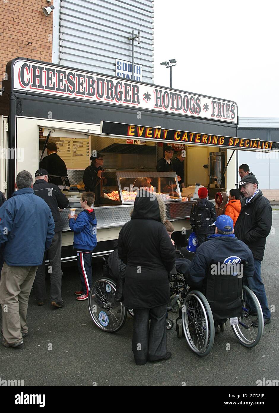 Fans grab a bite to eat from a burger van outside of the DW Stadium ...
