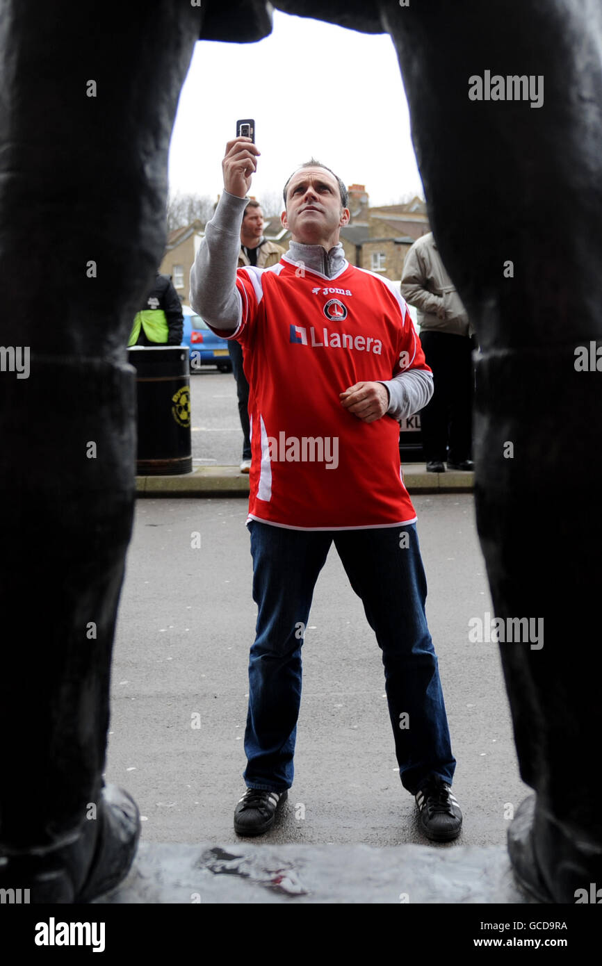 A Charlton Athletic fan take s a picture of the Sam Bartram statue ...