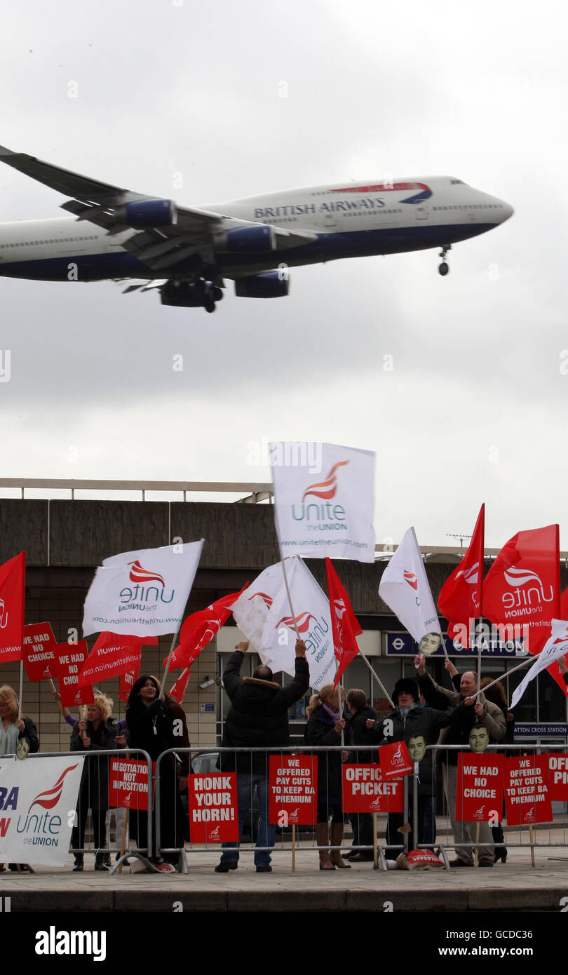 A British Airways jet flies overhead as members of the Unite union ...