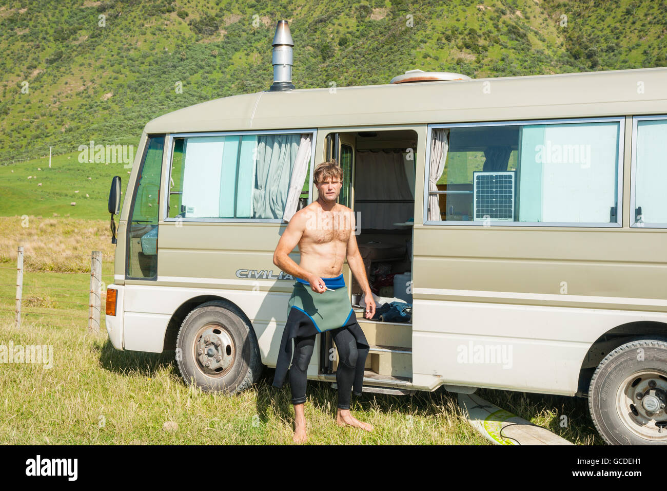 Traveling alone in mobile home surfer stands by door to his converted ...