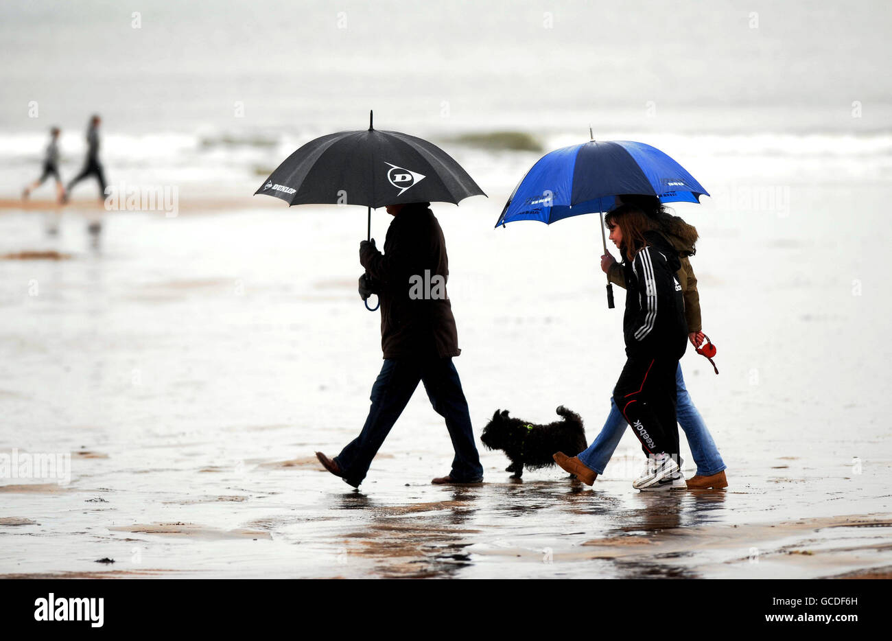 People talk a walk in the rain on longsands beach hi-res stock ...