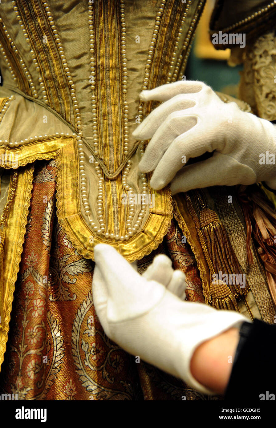 A member of staff adjusts details on Queen Victoria's Costume for the ...