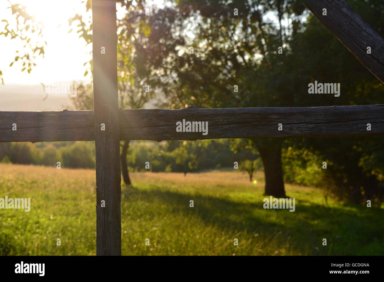Sunset seen through a wooden gate Stock Photo - Alamy