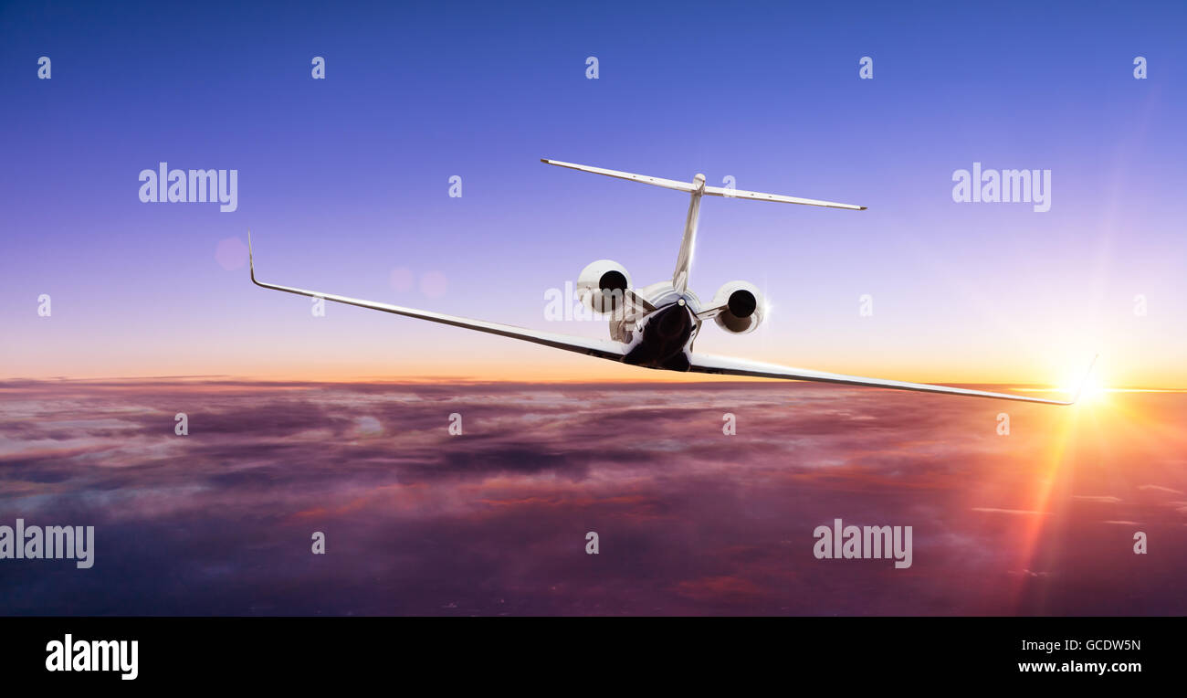 Private jet plane flying above clouds in beautiful sunset. Shot from ...