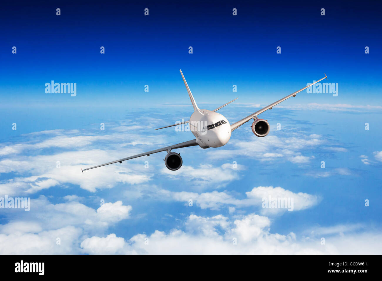 Commercial jet plane flying above clouds in day light Stock Photo - Alamy