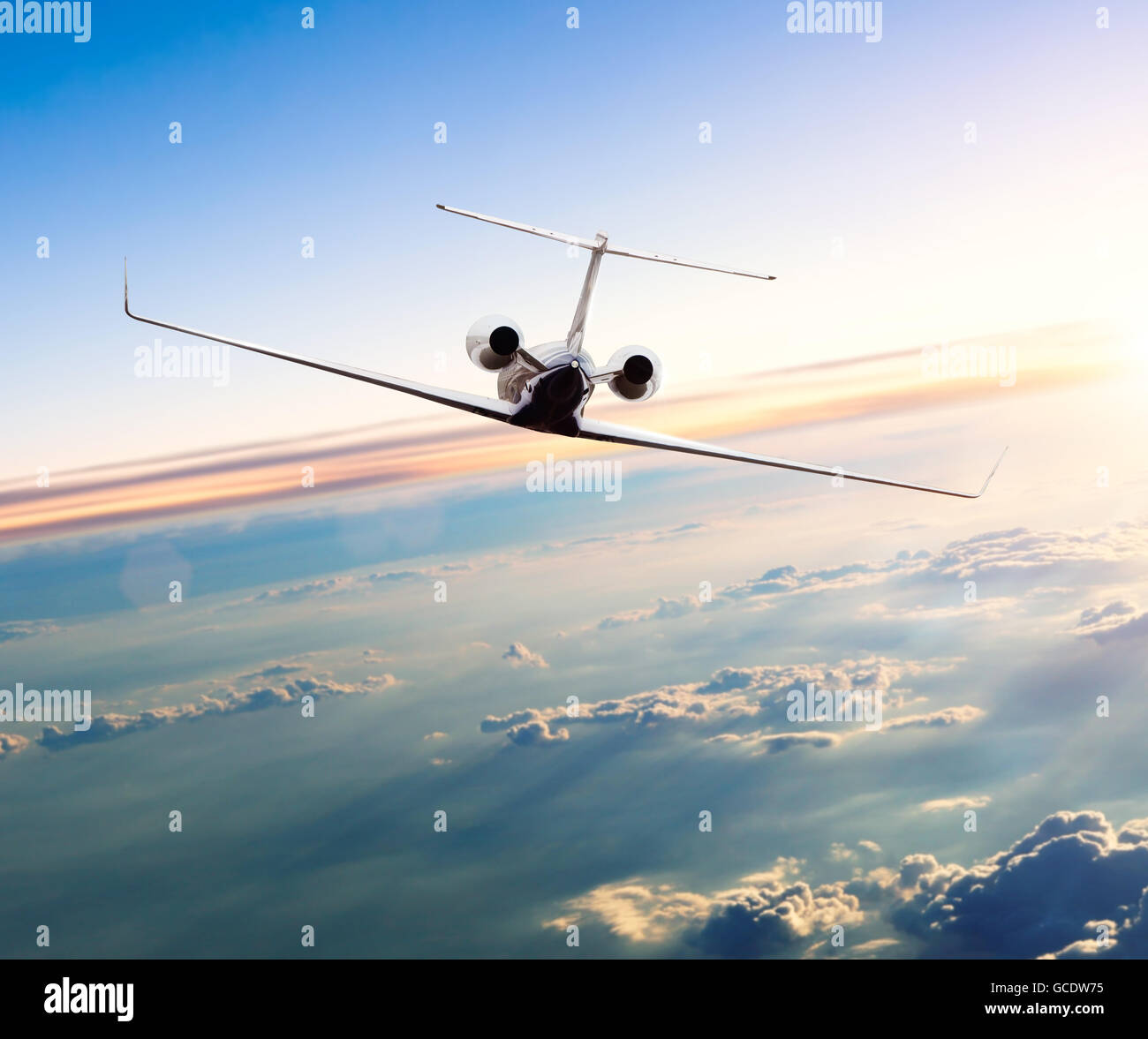 Private jet plane flying above clouds in beautiful sunset. Shot from ...