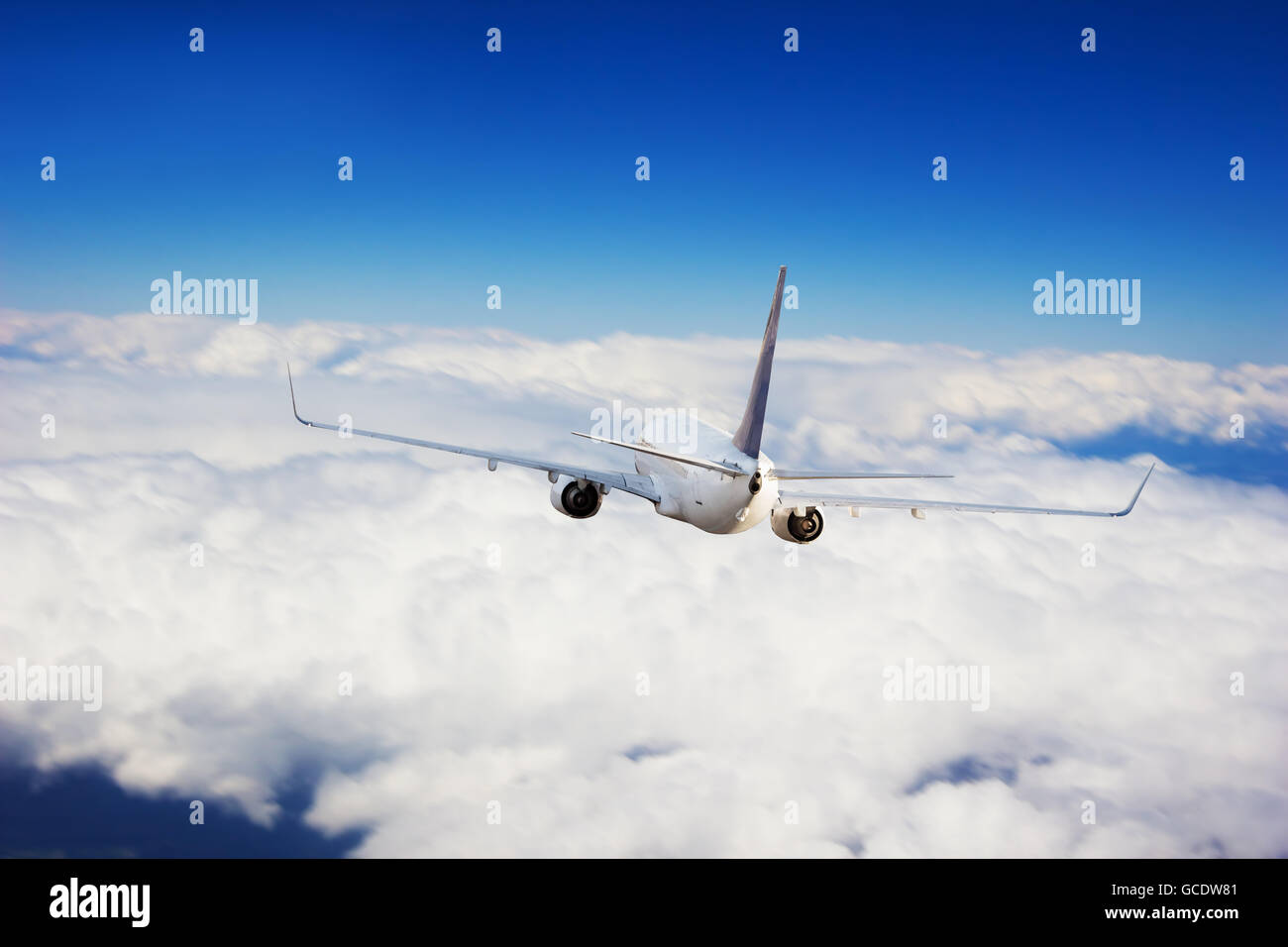 Commercial jet plane flying above clouds in day light Stock Photo - Alamy