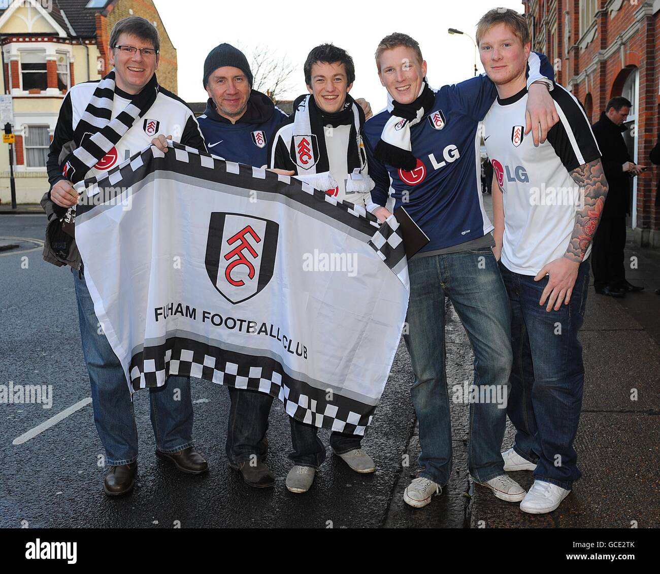 A group of male Fulham fans pose of the camera outside the ground ...
