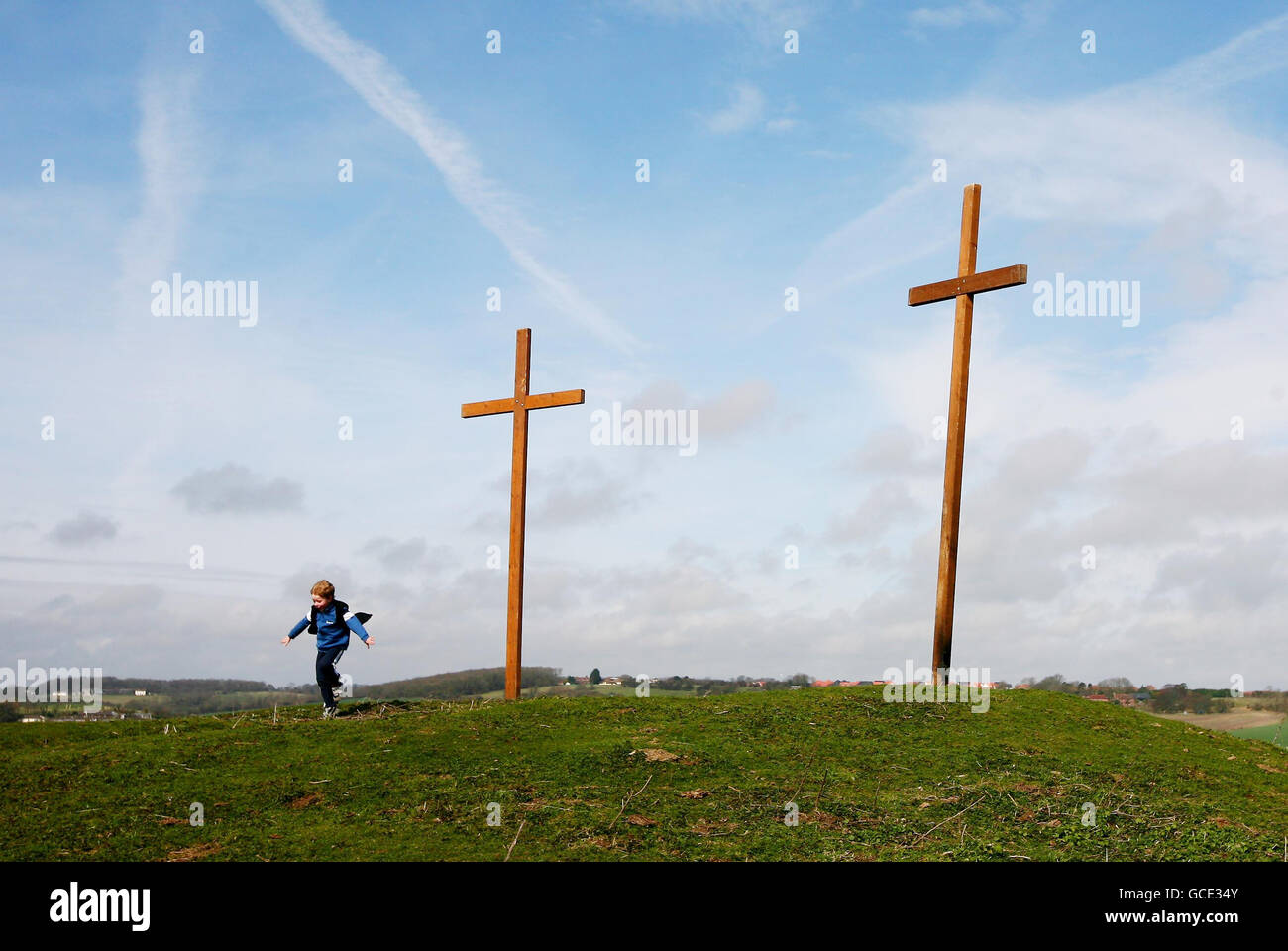 A young boy dances around two crosses on top of Sugar Loaf Hill in ...