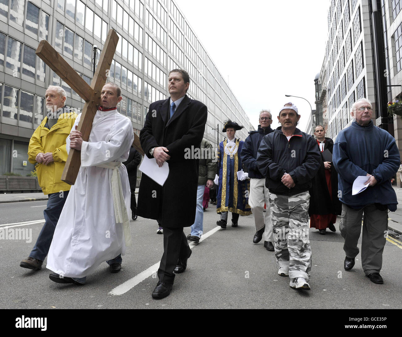 A member of The Passage of Westminster Cathedral carries the wooden ...