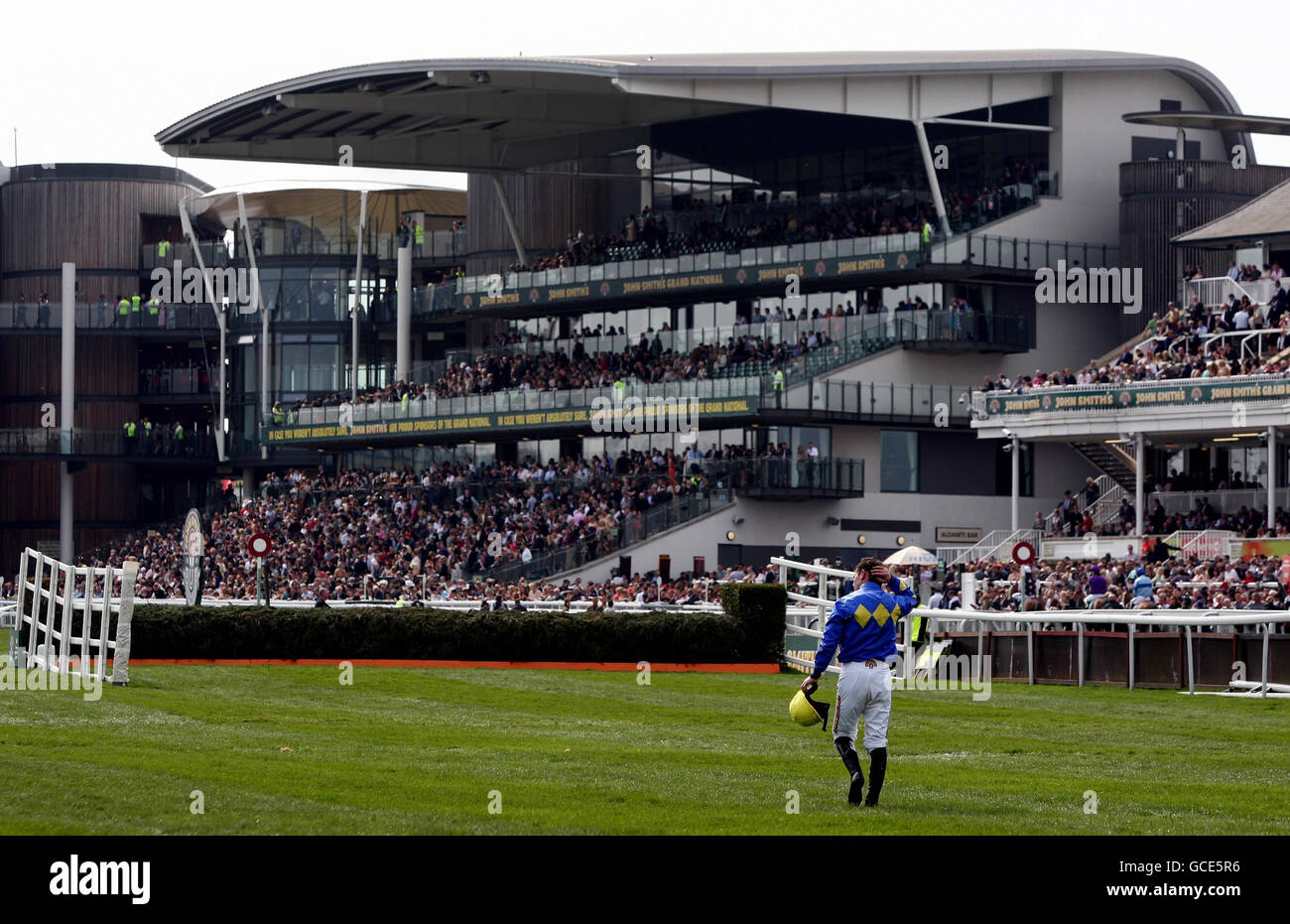 Jockey Graham Lee makes his way back after falling at the last on ...