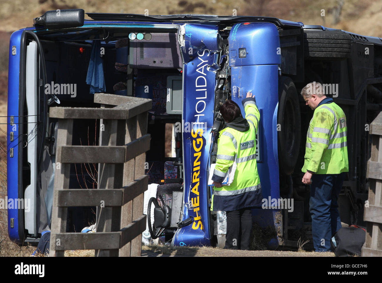 Accident investigators view the overturned coach after it crashed near ...