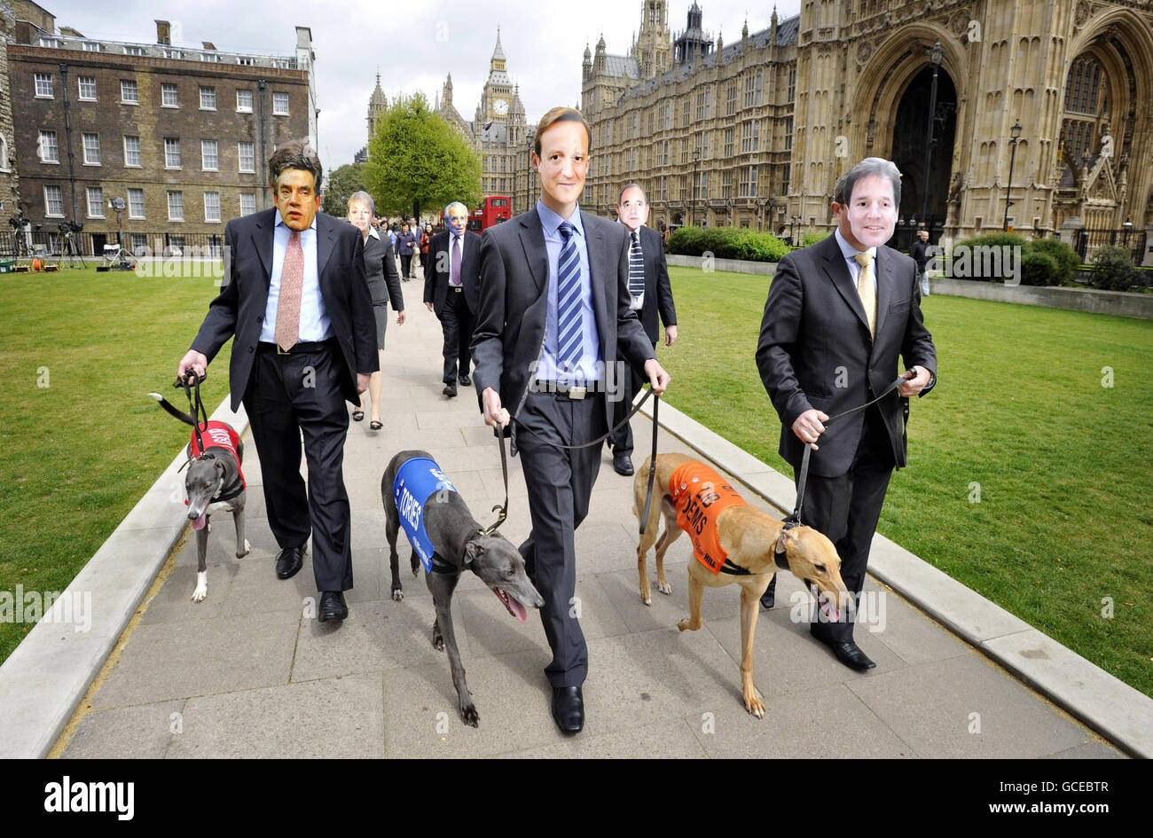 People wearing masks of Gordon Brown, David Cameron and Nick Clegg on ...