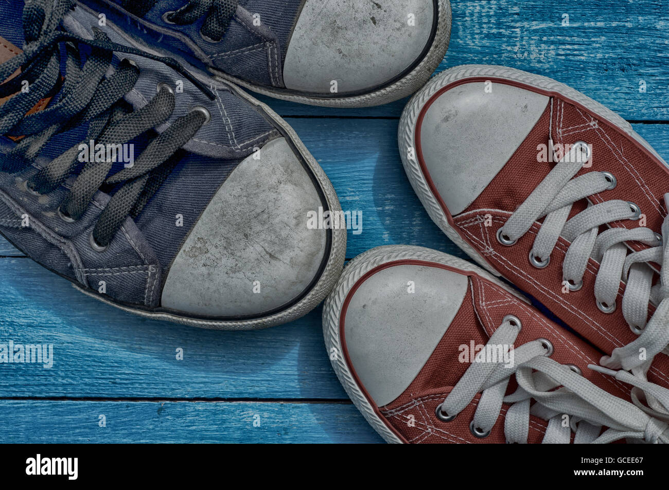 two pair of old worn sneakers on a blue shabby floor Stock Photo - Alamy