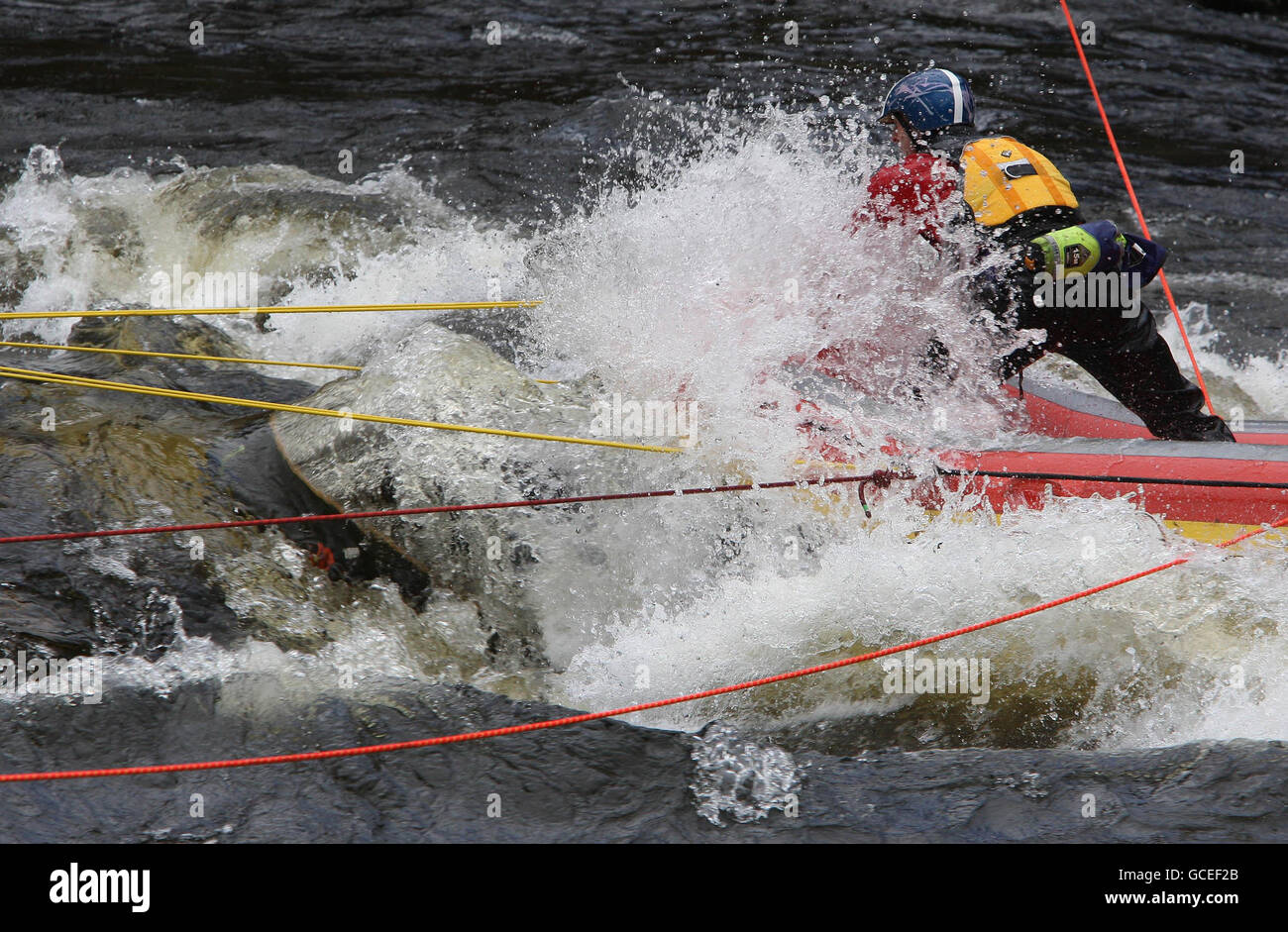 An emergency worker attempts to recover a kayak submerged under water ...