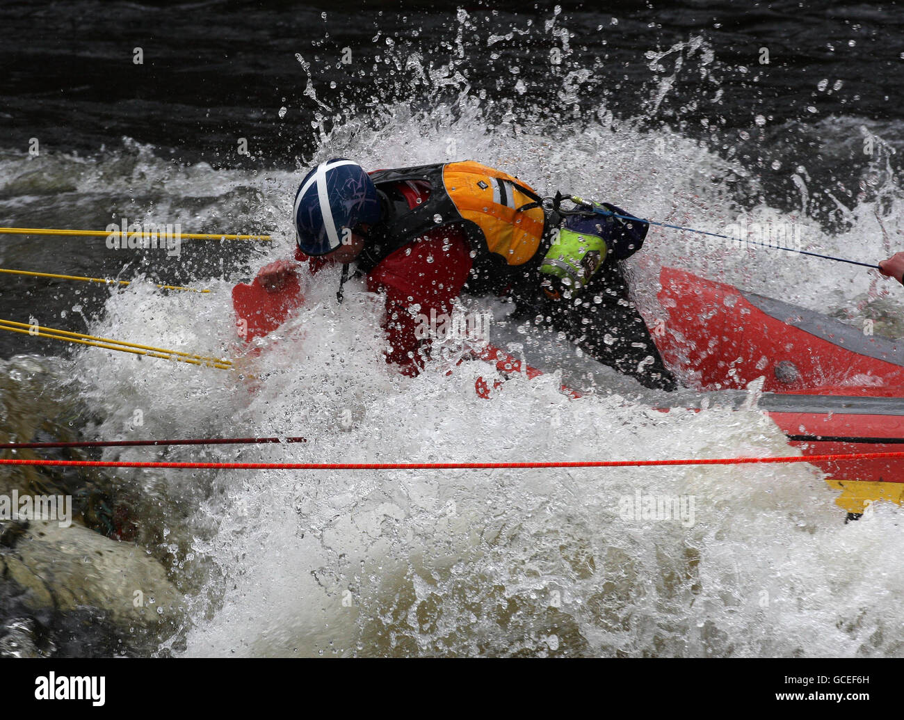 An emergency worker attempts to recover a kayak submerged under water ...