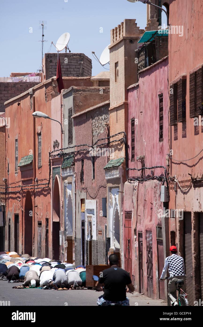 Muslims praying in the street, historic district of Marrakech, Morocco ...