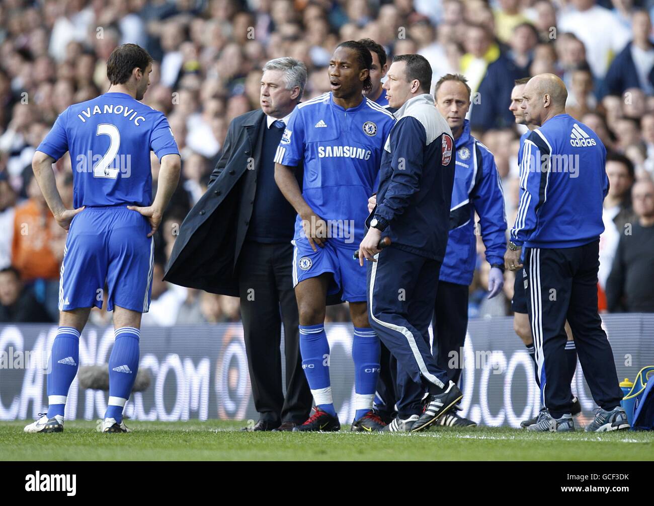 Chelsea's Didier Drogba (centre) receives treatment for an inmjury on ...