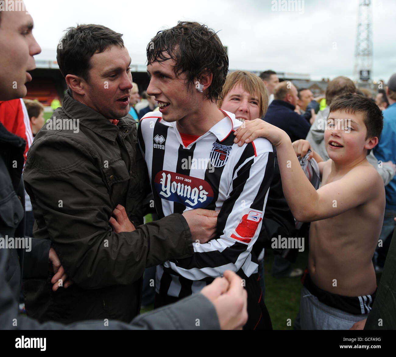 Jamie Devitt is mobbed by Grimsby Town's fans after victory during the ...