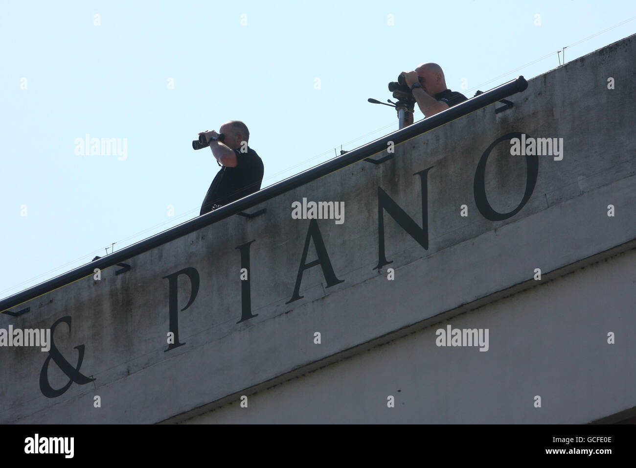 Police officers keep watch from a rooftop opposite the studios where ...
