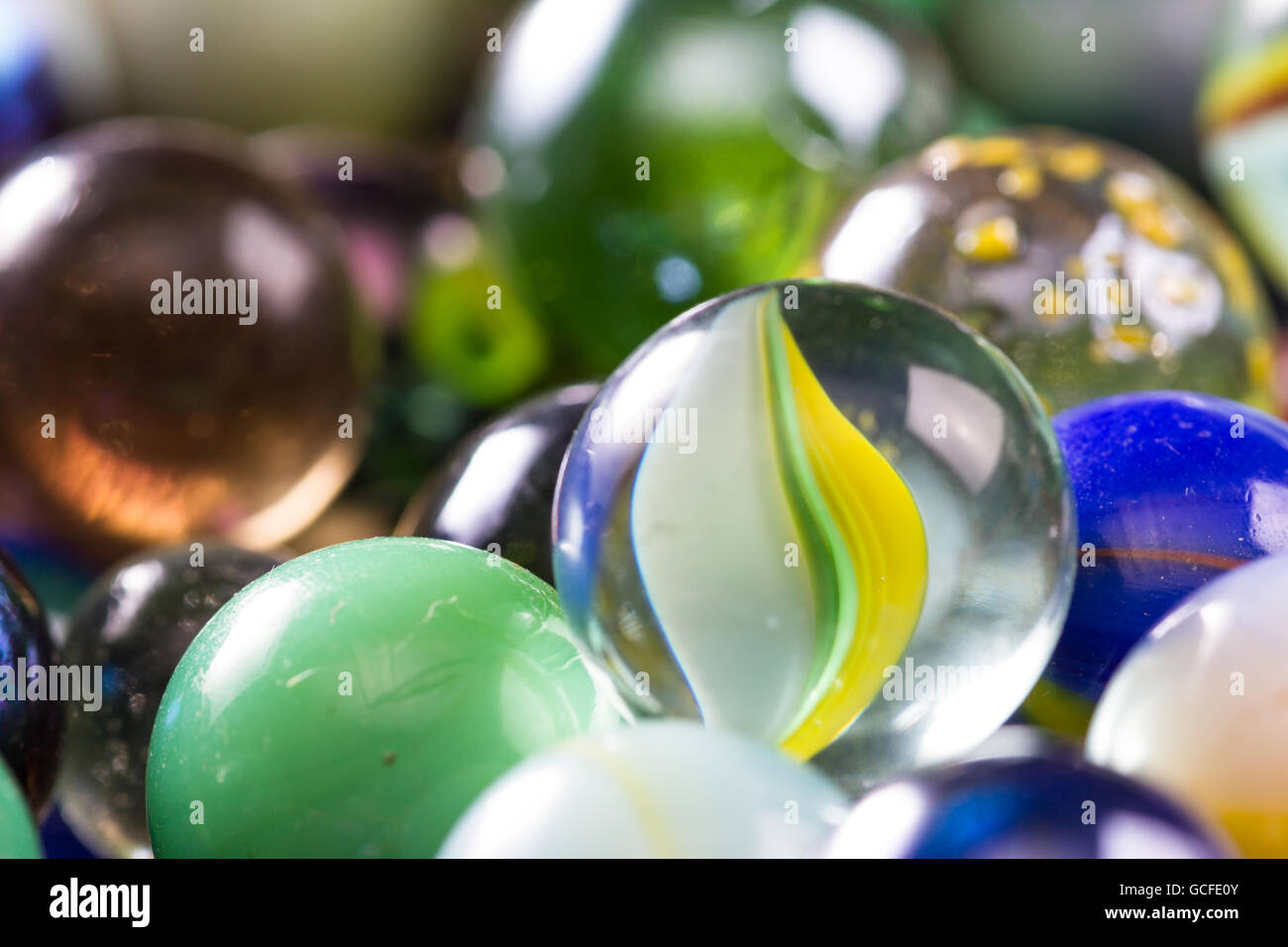 close up of a bunch of marbles in different colors for a background or ...