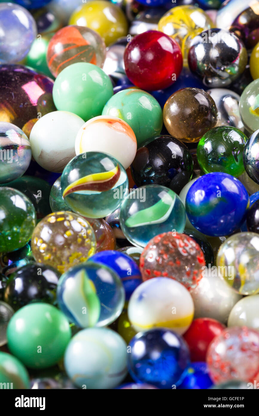 close up of a bunch of marbles in different colors for a background or ...