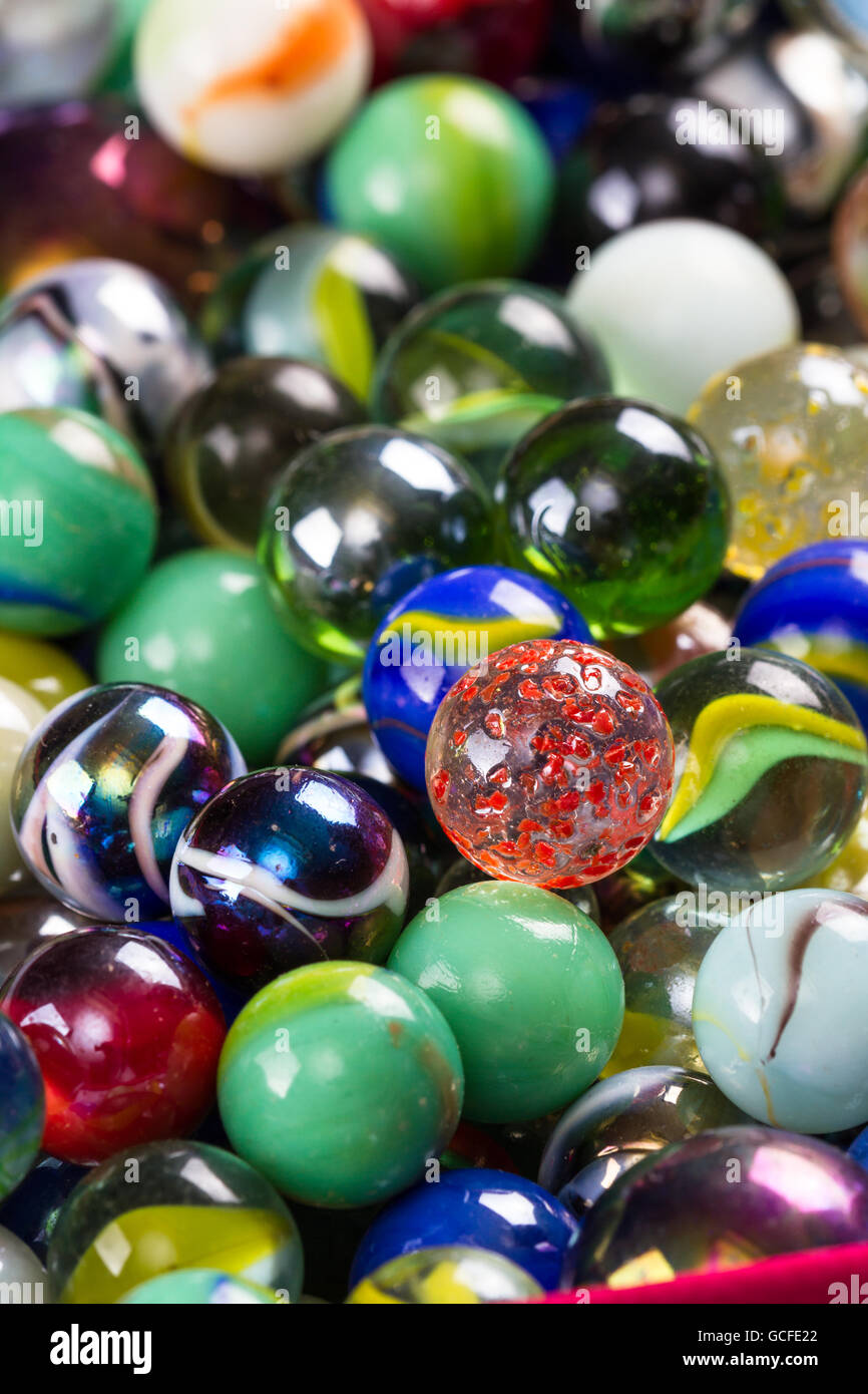 close up of a bunch of marbles in different colors for a background or ...