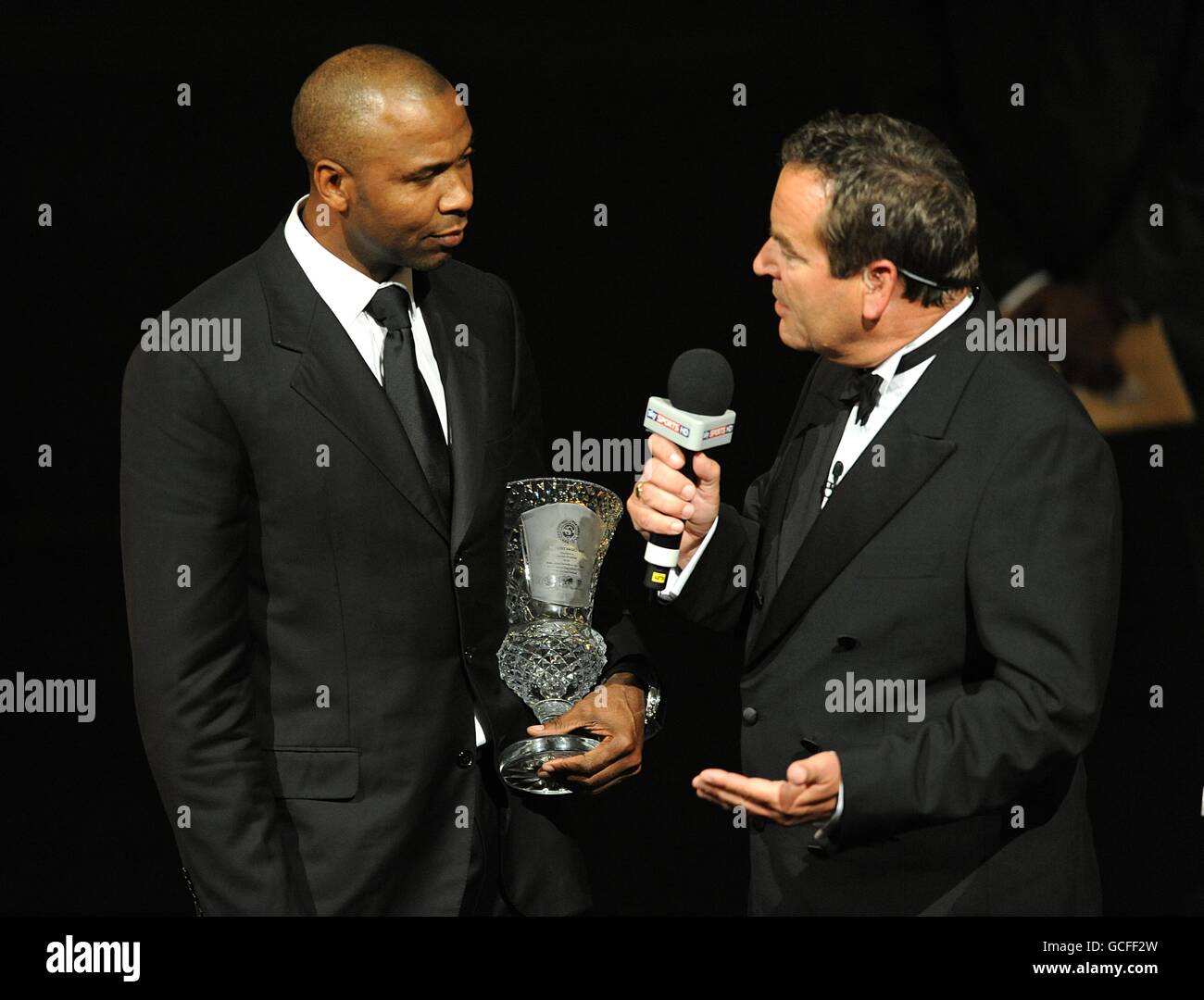 Lucas Radebe (left) collects his Special Merit Award award on stage ...