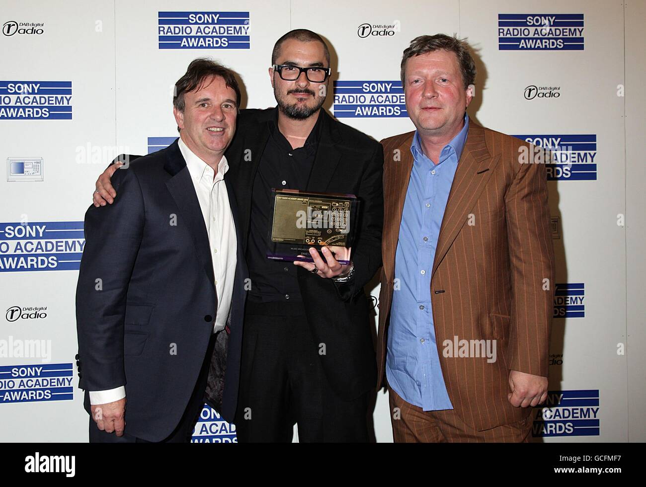 Zane Lowe (centre) collects his award for Music Broadcaster of the Year ...