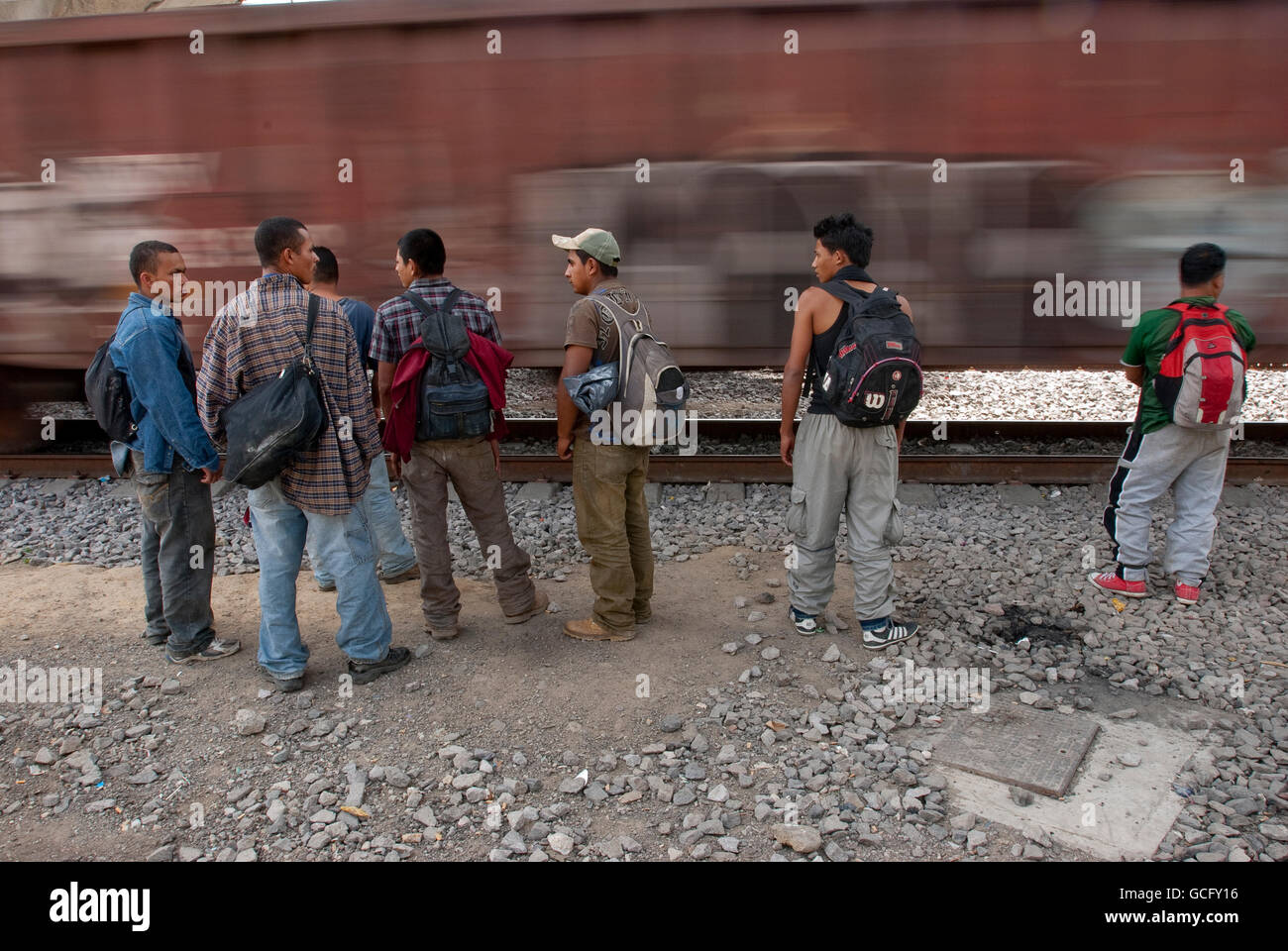 Central American migrants wait as a speeding freight train they hoped ...