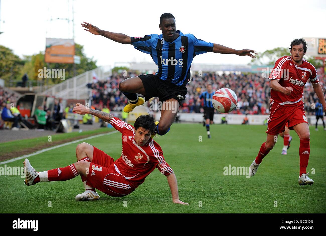 Charlton Athletic's Lloyd Sam (in air) and Swindon Town's Alan Sheehan ...