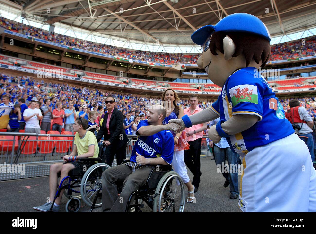 Cardiff City mascot Bartley Blue (right) shakes hands with fans before ...