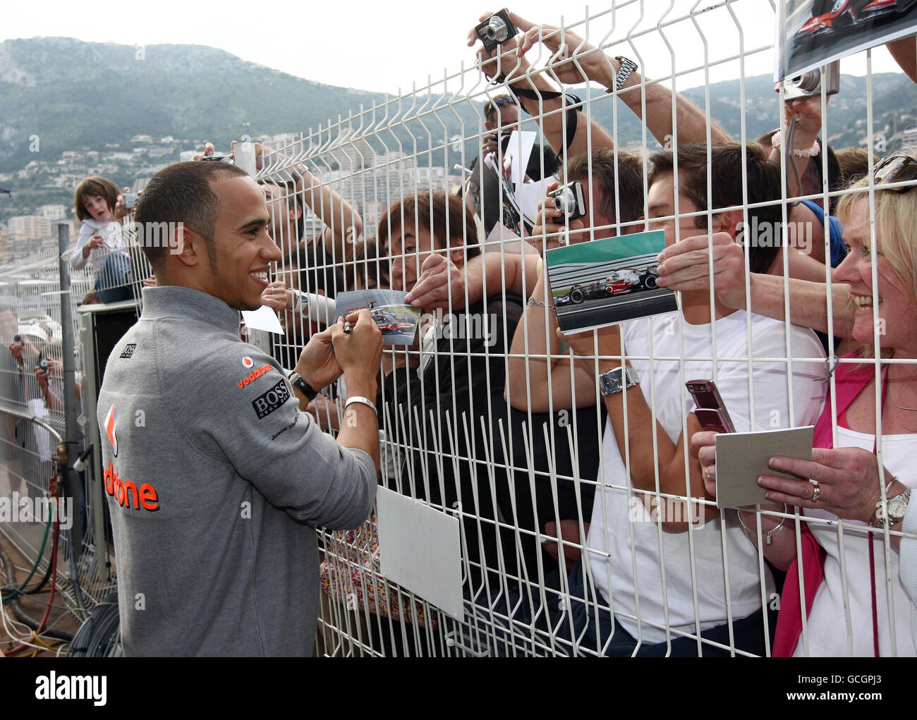 Lewis Hamilton signs autographs for fans in the paddock during paddock ...